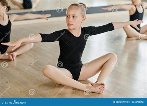 Jovencitas Y Compañeros De Clase Sentados En Una Pose Coreográfica Foto