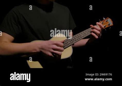 Camera Rotates Around Male Ukulele Player Young Man Touches Strings