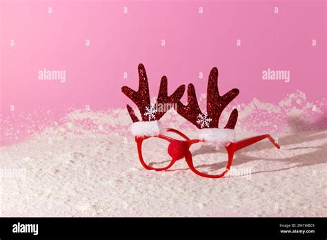 Holiday Glasses On Snowy Pink Background Creative Art Holiday Concept