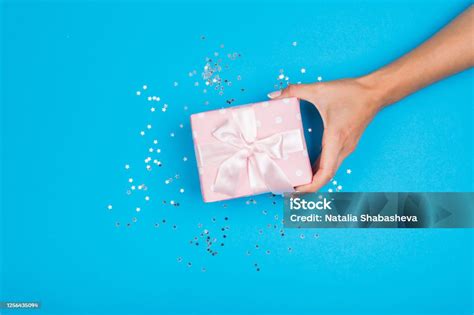 파란색 테이블 상단보기에 색종이로 장식 된 선물 이나 선물 상자를 들고 있는 여성 손 생일 이나 결혼식을 위한 플랫 구성 각도에 대한 스톡 사진 및 기타 이미지 Istock