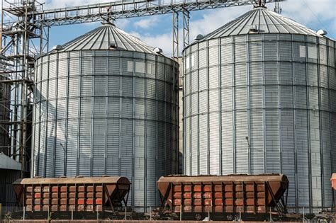 Two Metallic Silos Stand Tall At A Grain Storage Facility Capturing The ...