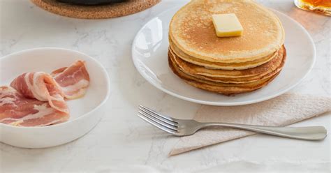 팬케이크와 베이컨을 얹은 테이블 옆에 차 한 잔 사진 Unsplash의 음식 이미지