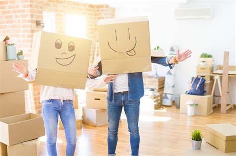 머리 위에 재미있는 얼굴상자를 입고 새 아파트에서 재미를 가진 커플 2명에 대한 스톡 사진 및 기타 이미지 2명 가정 생활 기이함 Istock