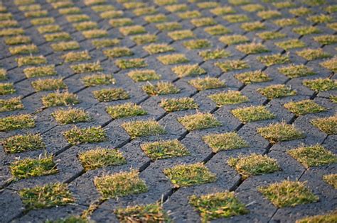 회색 자연석으로 만든 사각형 타일의 배경 질감입니다 도로의 콘크리트 가로 기하학적 포장 패턴 녹색 잔디 및 생태 주차장 녹색