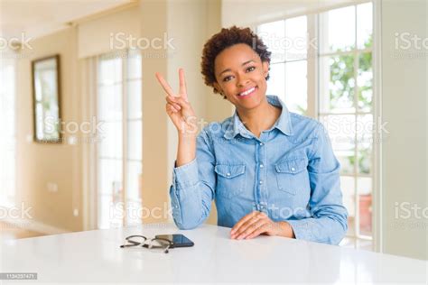 젊은 아름 다운 아프리카계 미국인 여자 표시 하 고 자신감과 행복 웃는 동안 두 손가락 숫자를 가리키는 손가락에 대한 스톡 사진