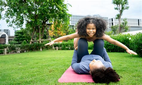 공원에서 요가 운동을하는 귀여운 재미있는 아이 딸과 함께 신중한 아프리카 엄마calm 흑인 어머니와 도시 공원 자연에서 요가를하는 혼합 인종 어린 소녀 명상을 가르치는 엄마