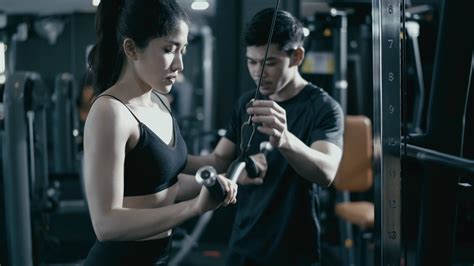 Woman Wearing Workout Clothes And There Is A Male Trainer To Take Care Of To Access The Service
