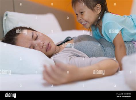 A Tired Mom Trying To Rest While Kid Is Disturbing Her Trying To Wake