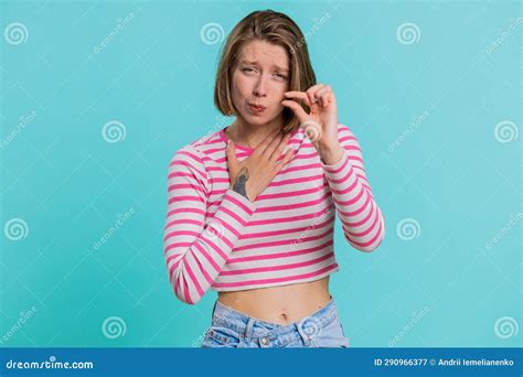 Woman Showing A Little Bit Gesture With Sceptic Smile Showing Minimum