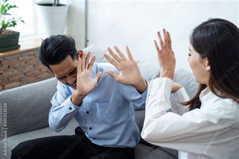 Young Asian Couple Having Bad Argument Fighting On Sofa At Home Wife Hitting Husband With Angry