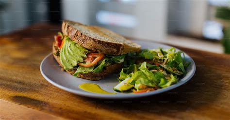 접시에 양상추와 토마토를 곁들인 샌드위치 사진 Unsplash의 구운 샌드위치 이미지