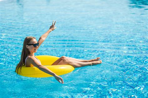 여름 방학 반짝이는 푸른 수영장에 노란 큰 반지에 떠있는 아쿠아 파크를 즐기는 아름다운 슬림 한 젊은 여성 공기 주입에 대한 스톡 사진 및 기타 이미지 Istock