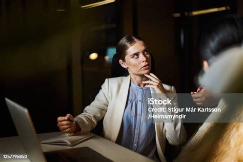 어두운 사무실의 책상에서 동료들과 이야기하는 젊은 사업가 3 명에 대한 스톡 사진 및 기타 이미지 3 명 경영자 계획 Istock