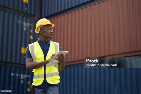 아프리카 노동자는 태블릿을 들고 걷고 수출및 수입을 위해화물선에서 컨테이너 상자를 확인 화물 운송에 대한 스톡 사진 및 기타 이미지 화물 운송 배달 안전모 Istock