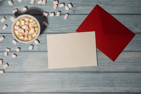 인사말 또는 초대 카드는 나무 배경에 흰색 커피 한 잔과 마시멜로가 있는 빨간 봉투로 조롱합니다 로맨틱 발렌타인 데이 텍스트를 위한 빈 종이 카드 복사 공간 휴일 아침 2