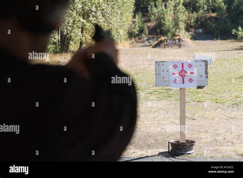 Man Aiming Gun At Target In Shooting Range Stock Photo Alamy