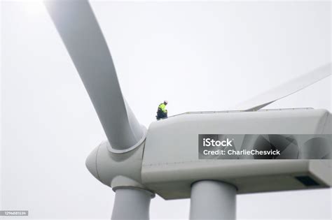 풍력 터빈의 지붕 에 서서 로프 검사를 준비하는 전문 로프 액세스 기술자 태양은 풍력 터빈 블레이드 뒤에 있습니다 풍력발전기에 대한 스톡 사진 및 기타 이미지 Istock
