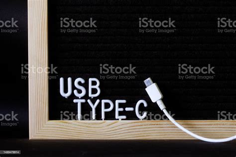 흰색 Usb Typec 커넥터는 비문이있는 검은 색 펠트 보드의 배경에 와이어가 있습니다 미니멀리즘 연결 데이터 전송 및 충전 가젯을 충전하는 현대적인 방법 매크로 공간을