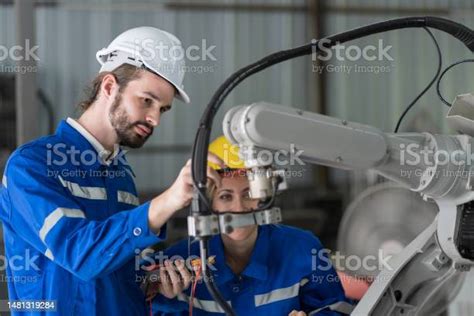 산업 제조 로봇 팔 유지 남성 여성 엔지니어가 작업장 공장에서 제조 라인을 위해 품질 및 유지 보수를 검사하는 자율 로봇 팔 용접 20 24세에 대한 스톡 사진 및 기타