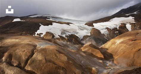 빙하는 건조하고 바위가 많은 풍경 위에 자리 잡고 있습니다 사진 Unsplash의 무료 눈 이미지