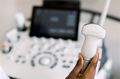 여성 아프리카 계 미국인 의사의 손에 초음파 스캐너의 사진을 닫습니다 진단 초음파 검사 흐린 배경에 현대 초음파 기계 초음파에