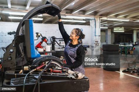 자동차 수리점에서 타이어 교체 기계에 바퀴를 고정하는 여성 정비사 20 24세에 대한 스톡 사진 및 기타 이미지 20 24세 20 29세 고용과 노동 Istock