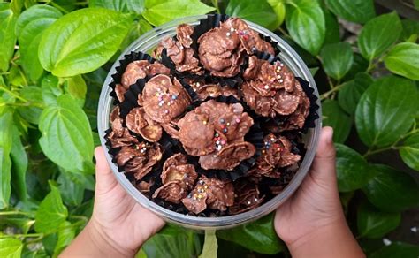 초콜릿 콘플레이크 케이크로 채워진 항아리를 들고 있는 손 인도네시아 이드 알 피트르의 전형적인 케이크 옥수수 시리얼로 초콜릿을