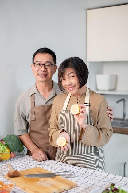 Premium Photo A Lovely Asian Couple Is In The Kitchen Wearing Apron Preparing To Cook Their