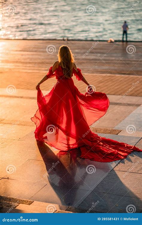 Sunrise Red Dress A Woman In A Long Red Dress Against The Backdrop Of