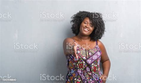 다채로운 입고 회색 그런 지 벽에 젊은 아프리카계 미국인 여자 드레스 인사와 환영으로 제공 하는 친절 한 악수를 미소 성공적인 사업입니다 동의에 대한 스톡 사진 및 기타