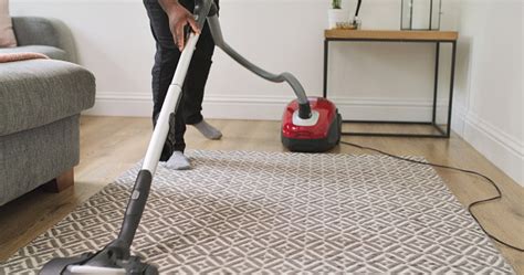 카펫 청소 및 먼지 오물 및 유지 보수를 위해 홈 라운지에 진공 청소기를 가진 사람 깨끗한 집을 위해 거실에서 진공 청소기로 청소하기위한 전기 제품이있는 청소기의 다리 35