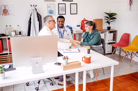 의사가 진료실에서 여성 환자와 대화하고 산소 농도를 측정하기 위해 의료 보조원과 함께 건강 상태를 확인하고 있습니다 20 24세에 대한 스톡 사진 및 기타 이미지 Istock