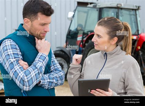 Male And Female Farmers Talking Next To A Tractor Stock Photo Alamy
