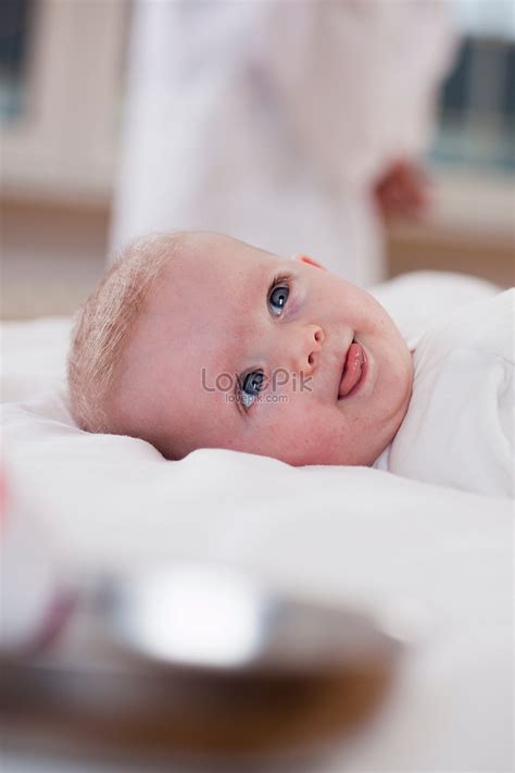 웃 고있는 침대에 누워있는 아기 사진 무료 다운로드 Lovepik