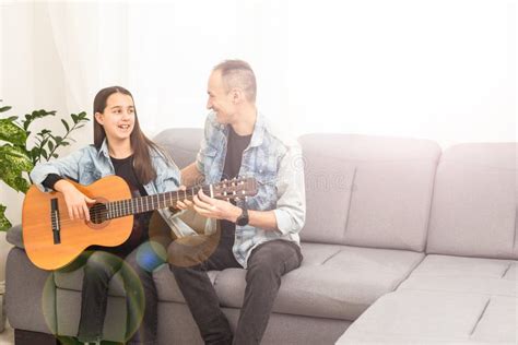 Father Guy Teaching Girl Teenager Daughter Guitar Playing At Home