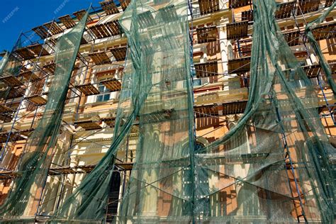 Premium Photo Building Structure With Netting Shade And Scaffolding Covered Premium Photo Building Structure With Netting Shade And Scaffolding Covered