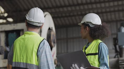 factory engineer workers checking and adjusting machine panel in the