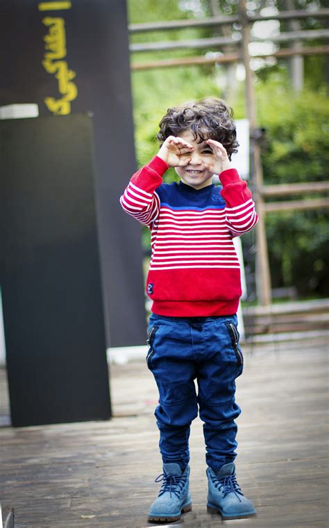 빨간색과 흰색 줄무늬 긴팔 셔츠와 파란색 데님 청바지를 입은 소년이 회색 위에 서 있습니다 사진 Unsplash의 무료 사진 이미지