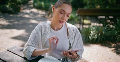 Relaxed Girl Scrolling Smartphone Searching Information At Park Table