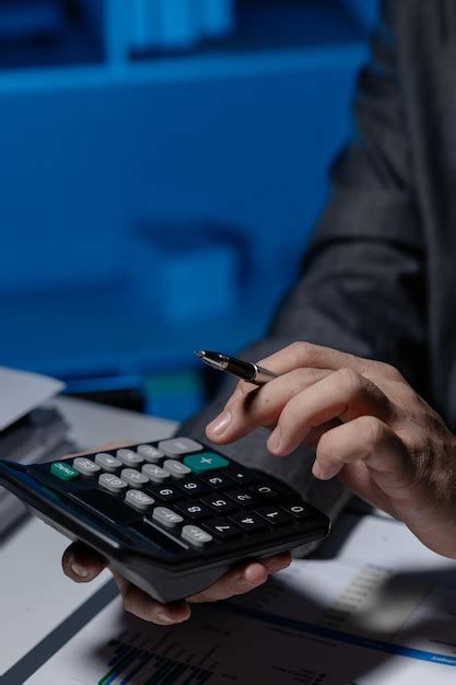 Premium Photo An Employee Is Calculating Important Numbers On A Document An Entrepreneur Is
