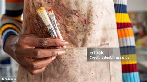 페인트 브러시를 들고 있는 아프로 여성 아티스트의 손 빛 앞치마 배경으로 예술 스튜디오 복사 공간 손에 대한 스톡 사진 및 기타 이미지 Istock