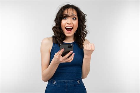 파란 드레스를 입은 미소를 지은 즐거운 소녀는 흰색 배경에 행복과 스마트 폰과 반짝이를 개최 20 24세에 대한 스톡 사진 및 기타 이미지 Istock