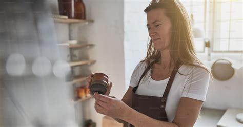 그녀의 창조적 인 작업장에 홀로 서서 새로 만든 유약 도자기 조각을 검사하는 미소 짓는 여성 장인 사진 Unsplash의 복사 공간 이미지