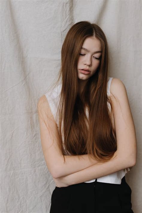 실내 간단한 배경 갈색 머리 감정 고요한 교활한 기댄 긴 머리 내면의 평화 내성 라이프스타일 묵상 미니멀리스트 부드러운 조명 사색 중인 소매