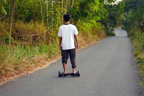 Premium Photo Young Man Riding Hoverboard On Black Asphalt Road Electric Scooter Close Up Of