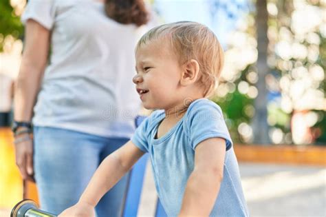 Madre E Hijo Jugando Al Swing En El Parque Infantil Imagen De Archivo