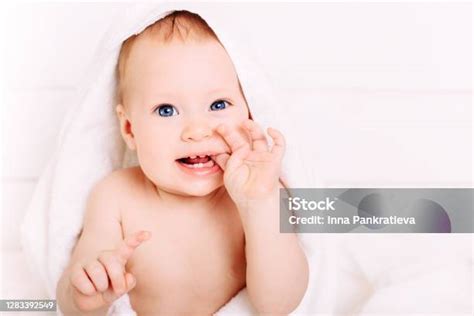 큰 흰색 수건에 8 개월의 귀여운 아기는 그의 머리에 옷을 입고있다 6 11 개월에 대한 스톡 사진 및 기타 이미지 6 11