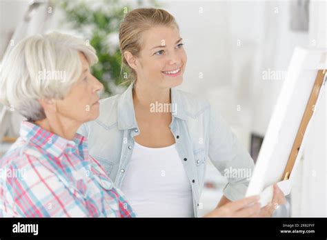 Woman Putting A Frame On The Wall Stock Photo Alamy