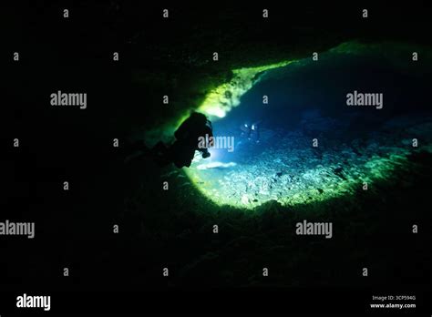 Cave Diver Swimming Through A Halocline Phenomenon In A Tajma Ha Cenote