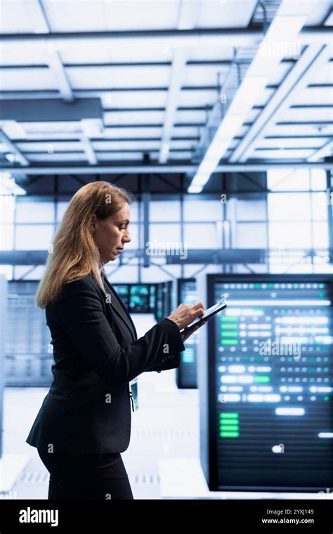 Software Developer Using Tablet In Data Center With Advanced Tech Ensuring Cybersecurity And